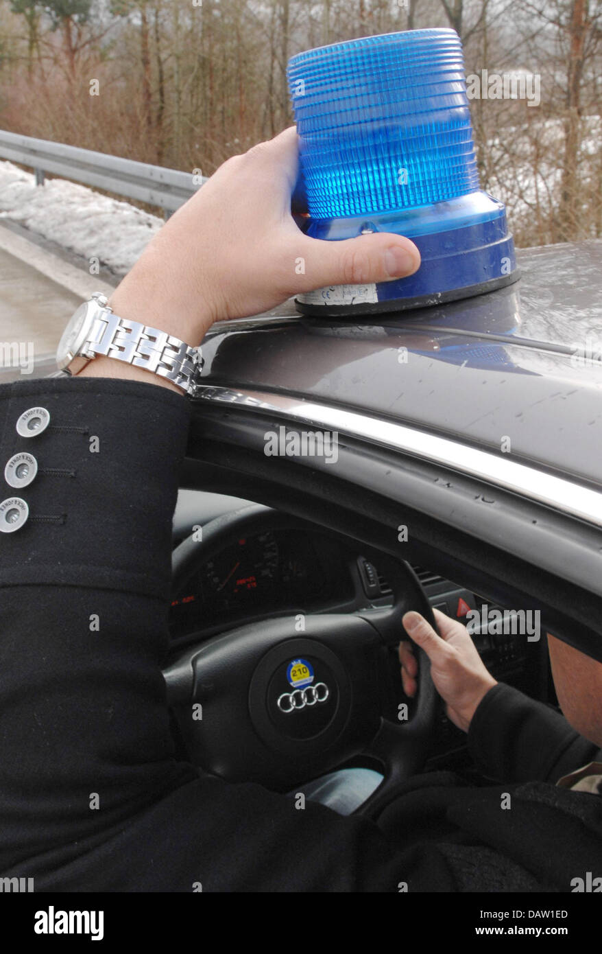 A police officer puts on the blue light in a civil patrol during ...