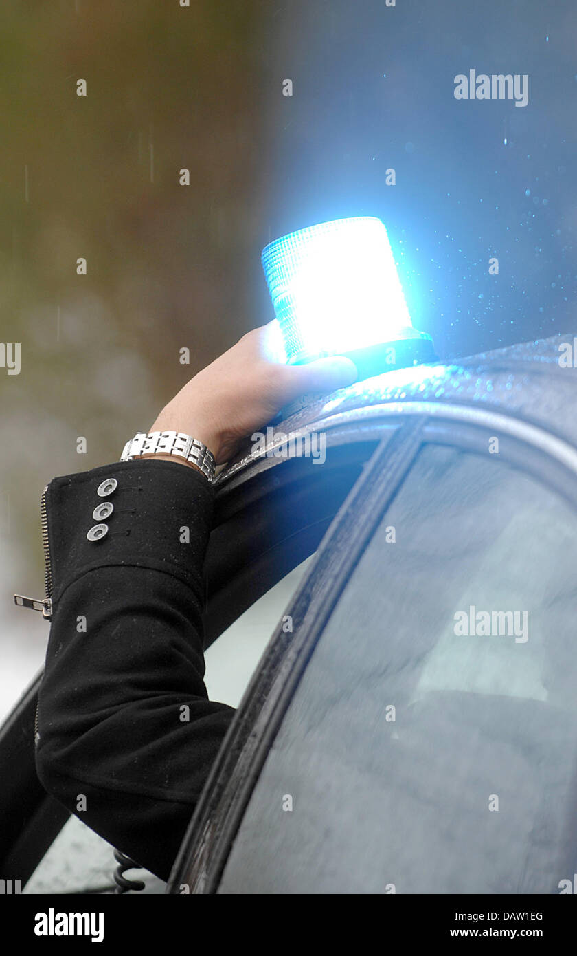 A police officer puts on the blue light in a civil patrol during ...
