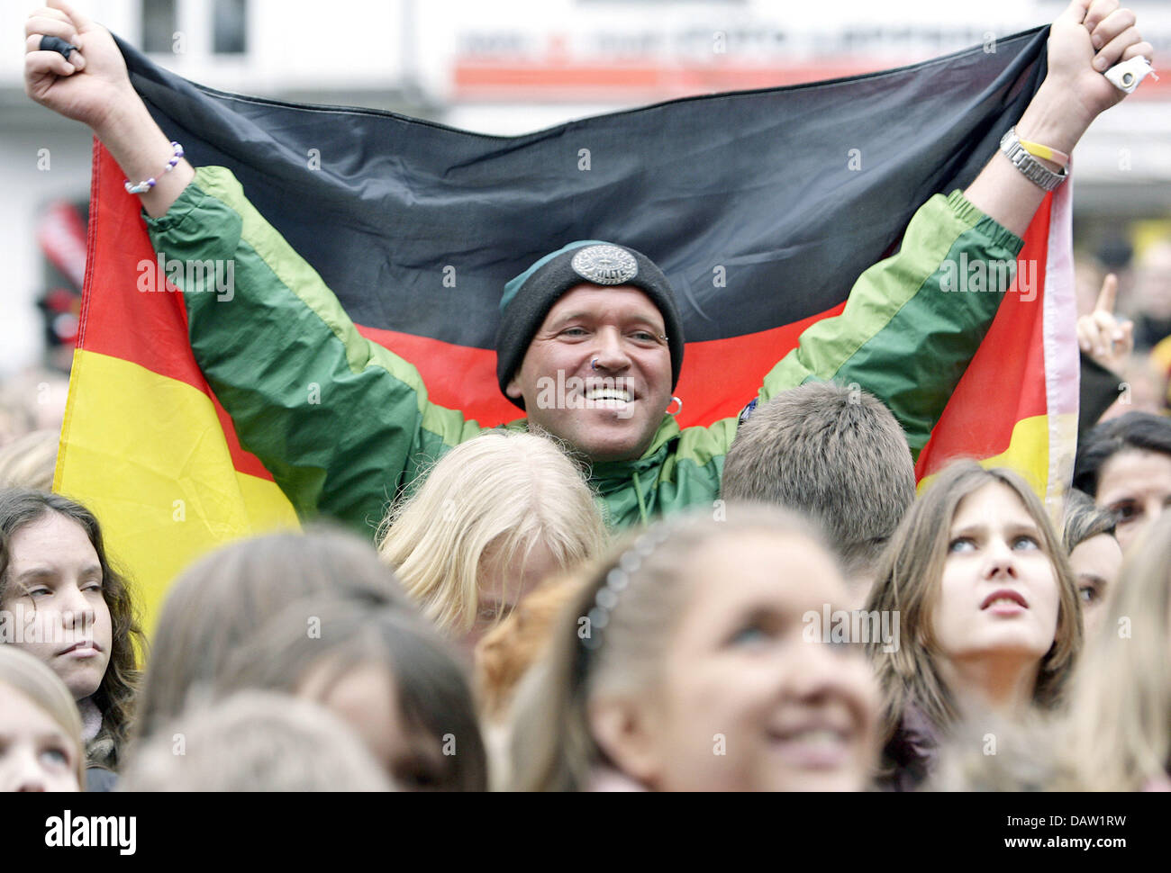 A fan of the German national handball team stands holding a German flag ...