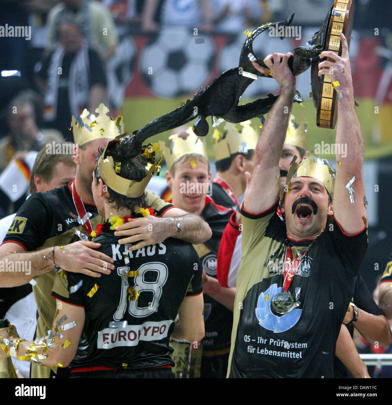 German national handball player Florian Kehrmann (R) holds up the World ...