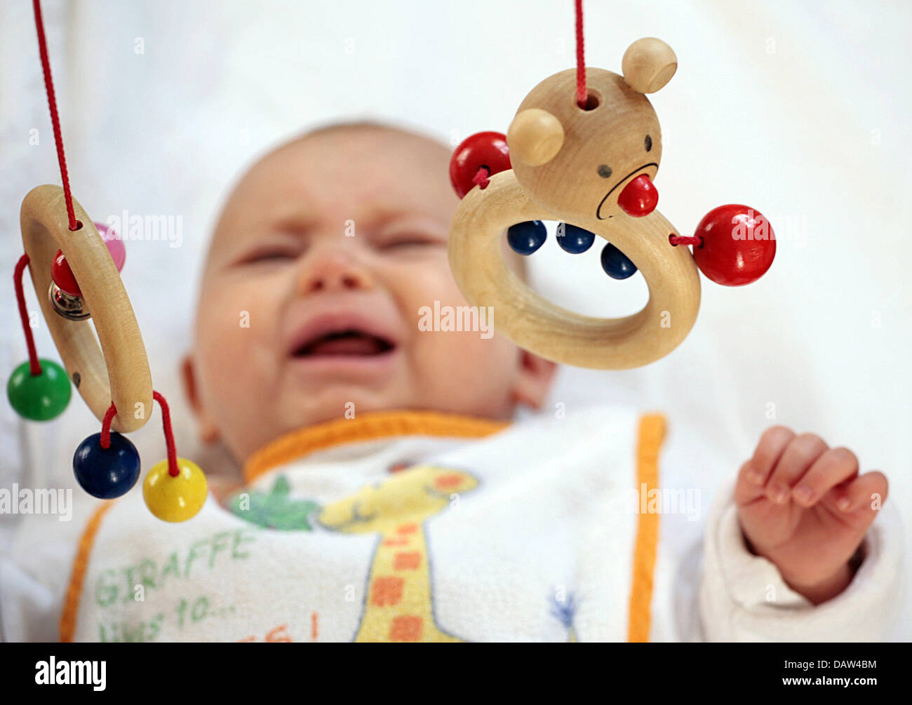 A crying baby lies under its dangling toys in Frankfurt Main, Germany ...