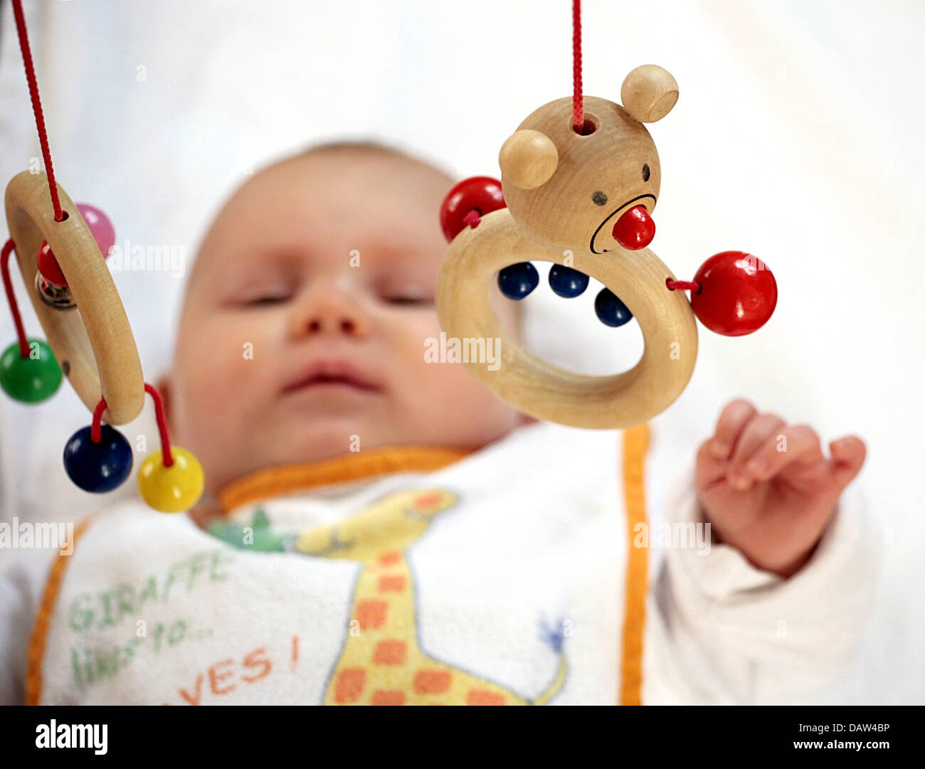 An almost three-year old baby is pictured under its dangling toys in ...