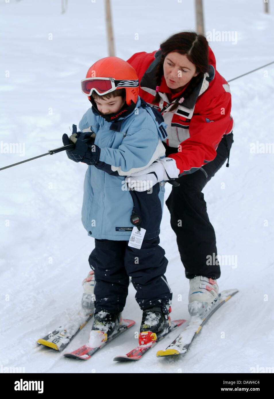 A skying teachers shows a child how to use a ski-lift during an SBZ ...