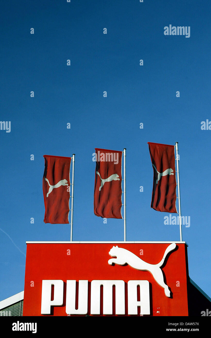 The PUMA company logo and three red flags with the white company logo ...