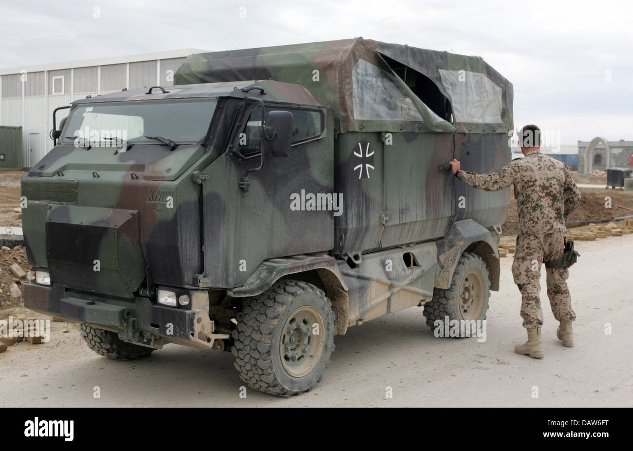 A 'Mungo' armoured vehicle of the German ISAF contingent and a soldier ...