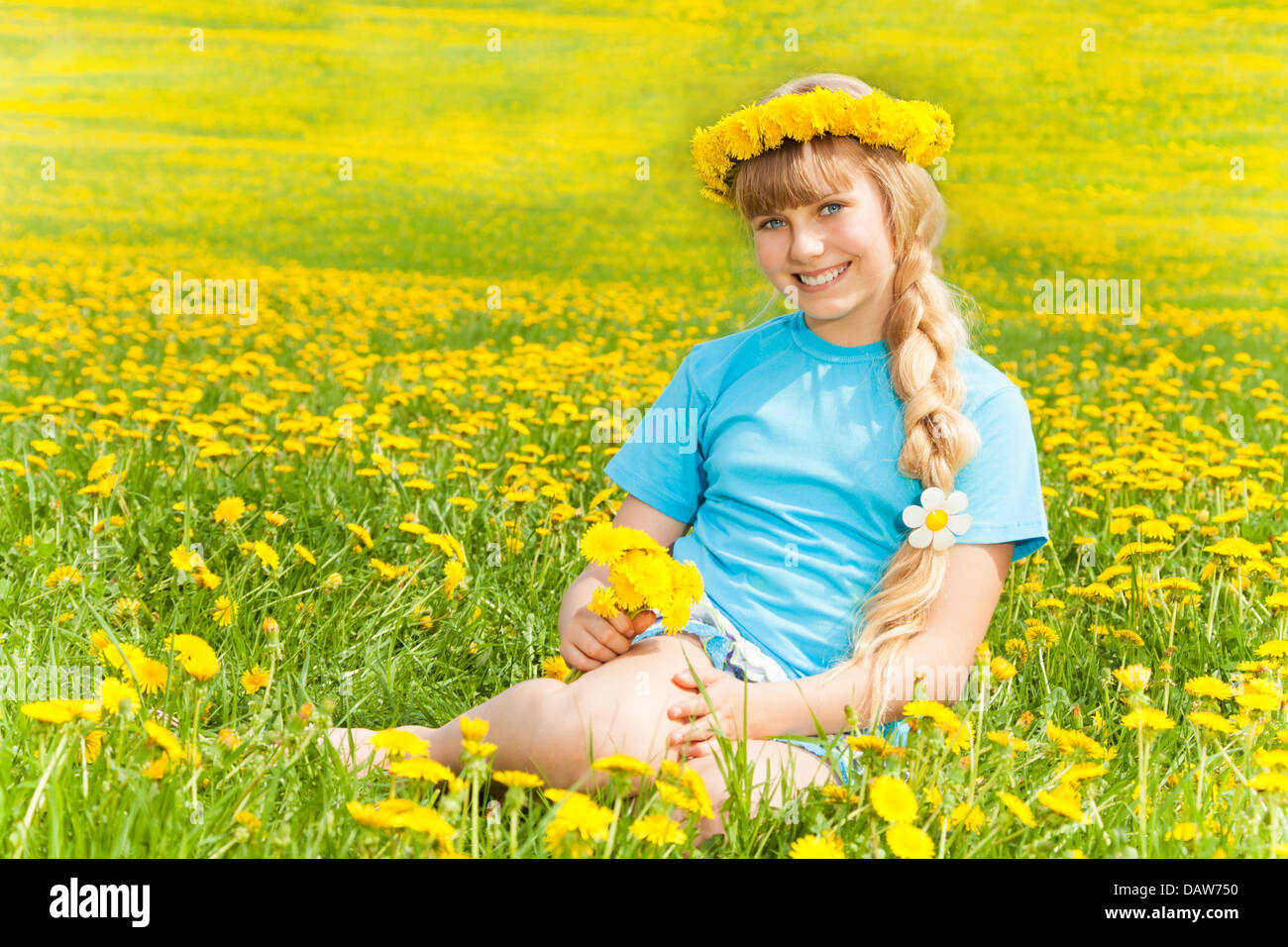 Beautiful 10 years old blond girl sitting in the yellow flower ...