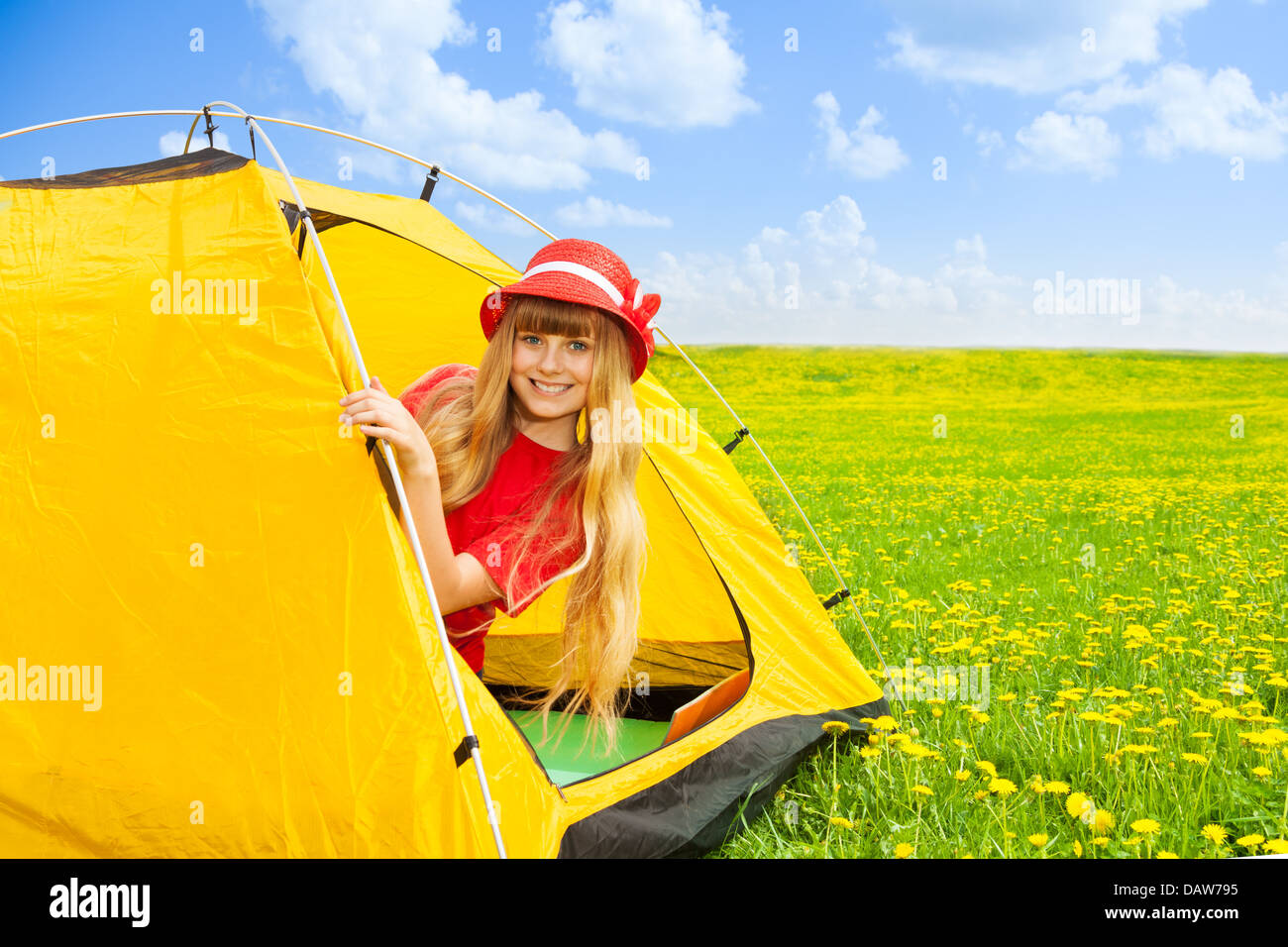 Blond happy laughing little 10 years old girl sitting in camping tent ...