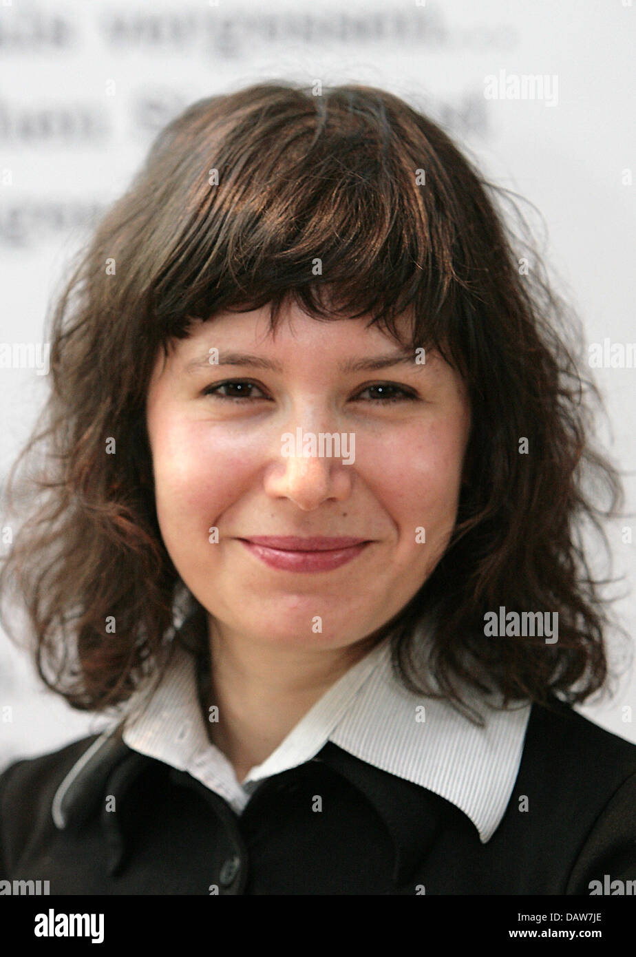 Sharone Lifschitz smiles in front of a poster with sentences at a press ...