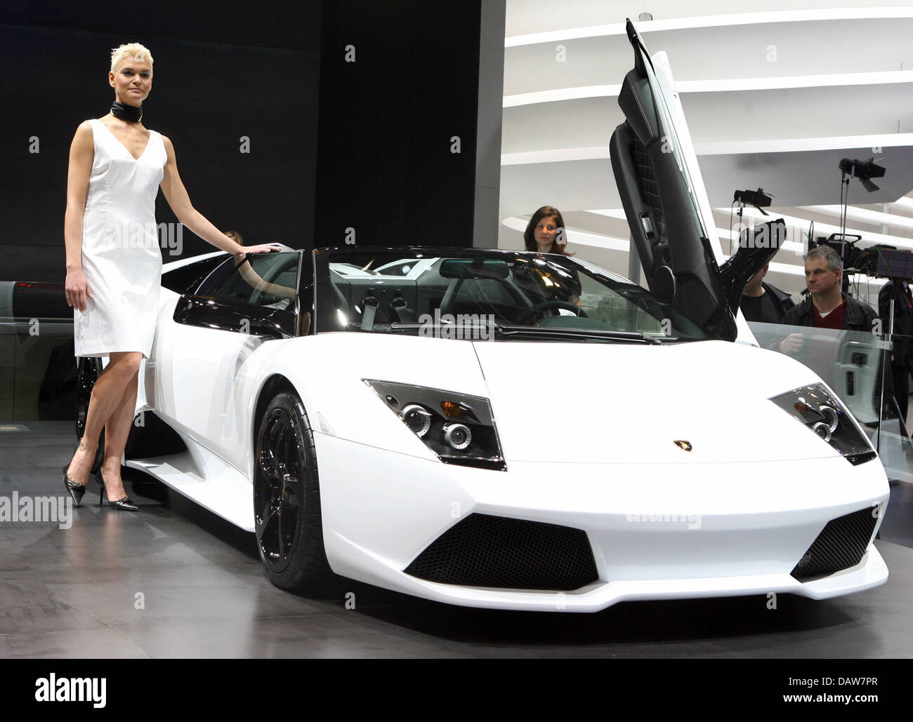 A model leans on a Lamborghini sports car at the Lamborghini stand at ...