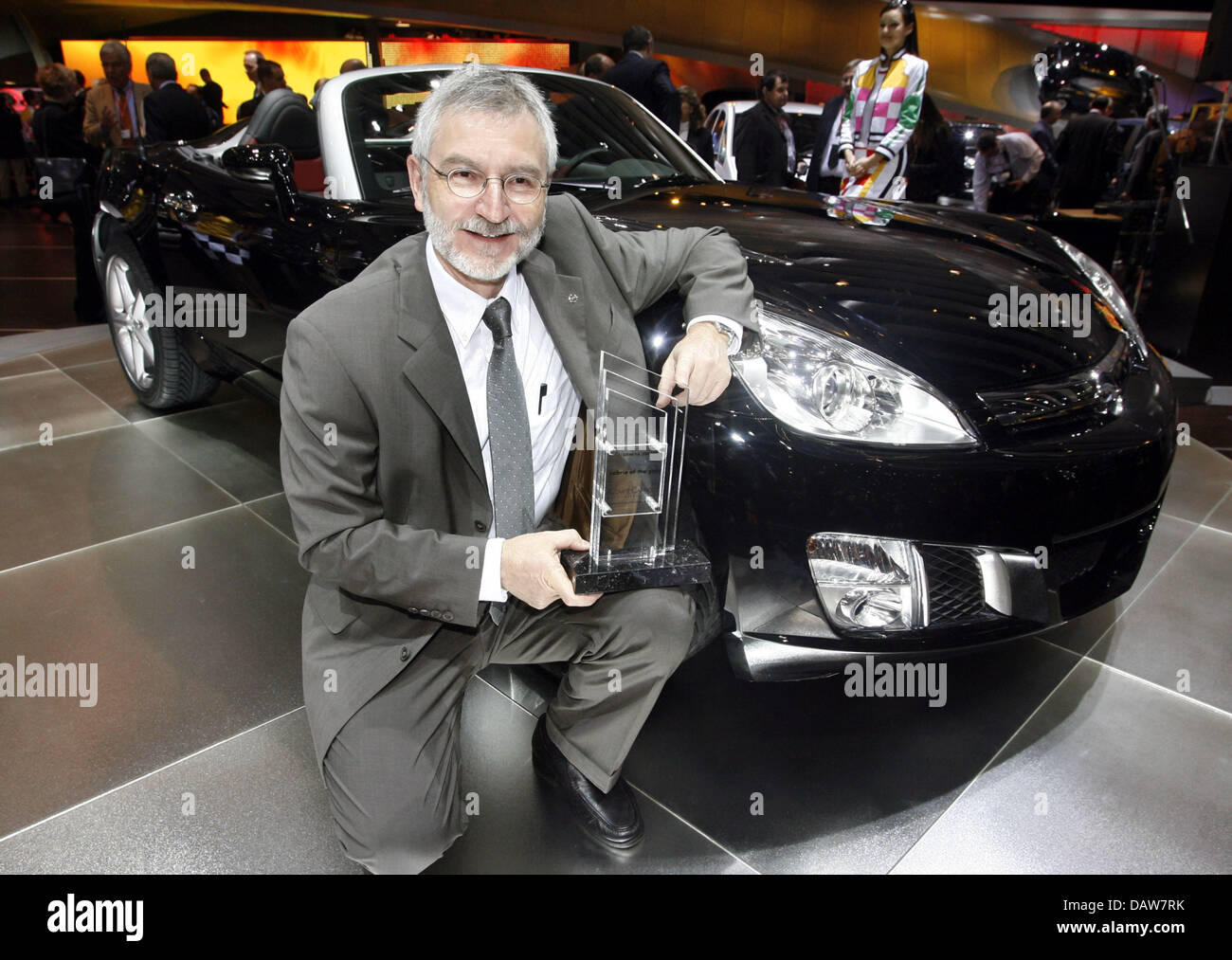 The CEO of Opel Hans Demant shows a trophy in front of an Opel GT after ...