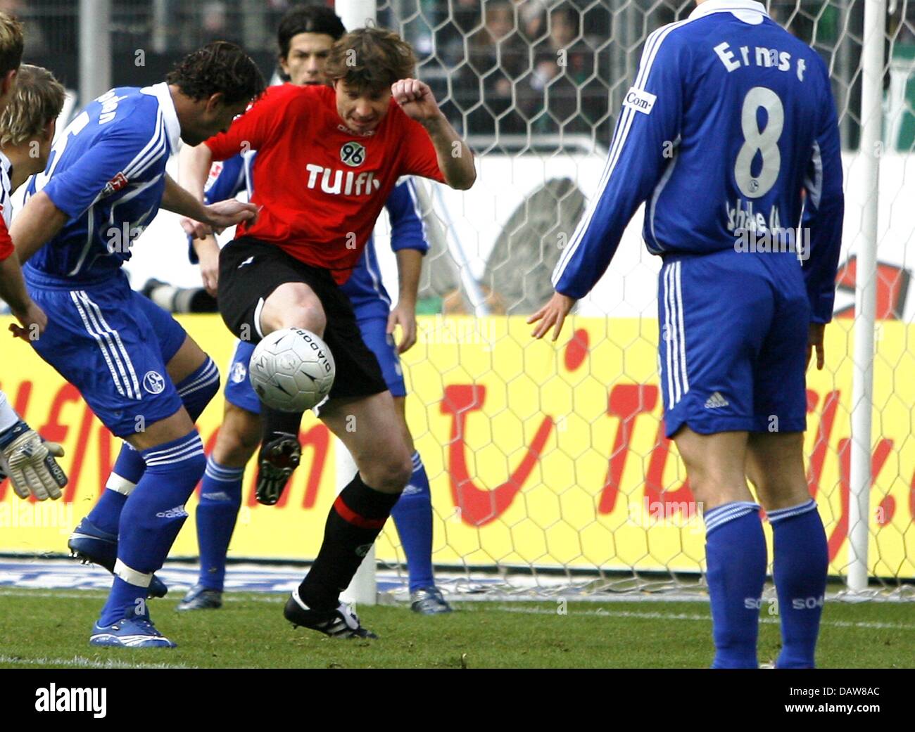 Michael Tarnat (C) of Hanover tricks out Schalke's Marcelo Bordon and ...