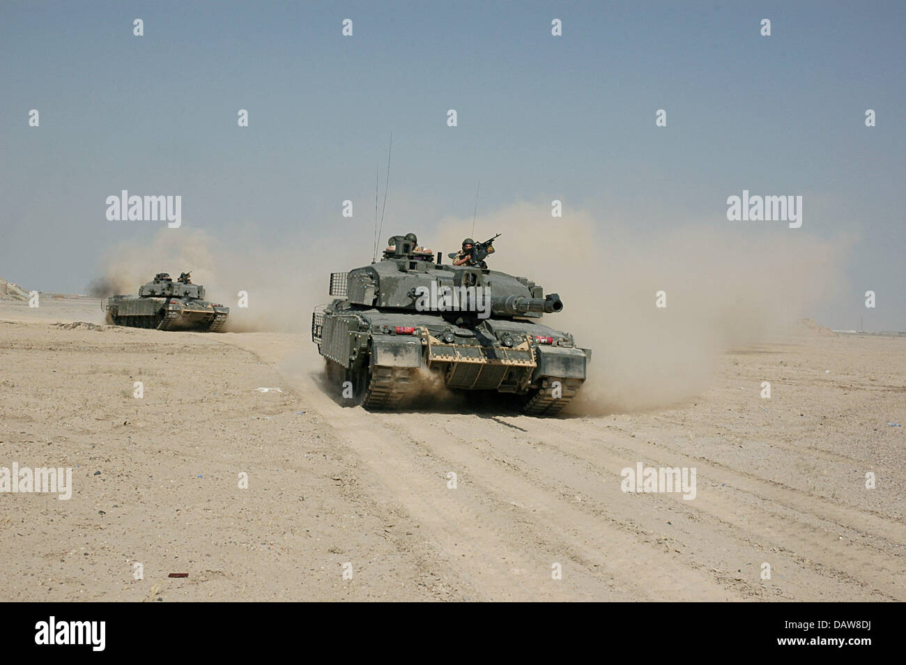 British soldiers patrol on two Challenger 2 tanks in the desert near ...