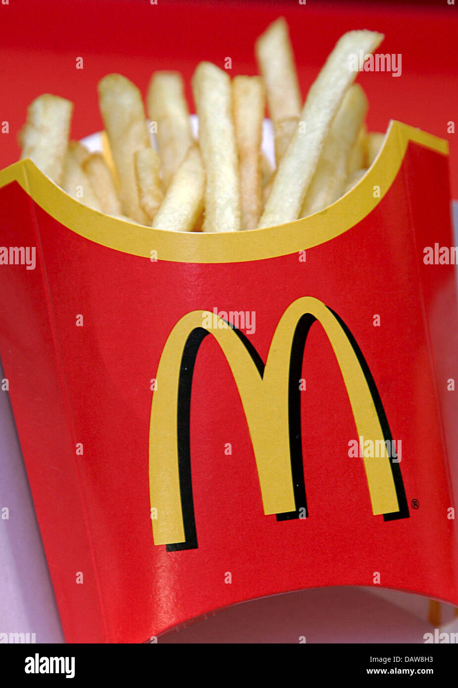 The picture shows a box full of french fries in a McDonald's branch ...