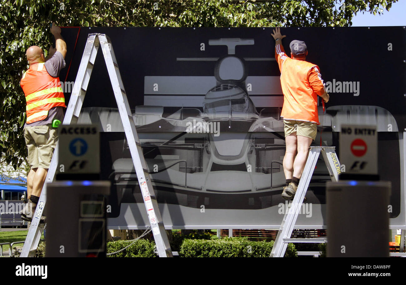 Workers set up a large F1 advertising poster for the Formula 1 ...