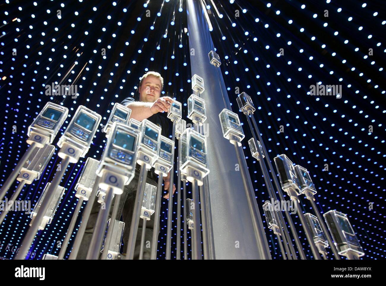 A worker arranges mobile phones at the O2 stand at the world's largest ...