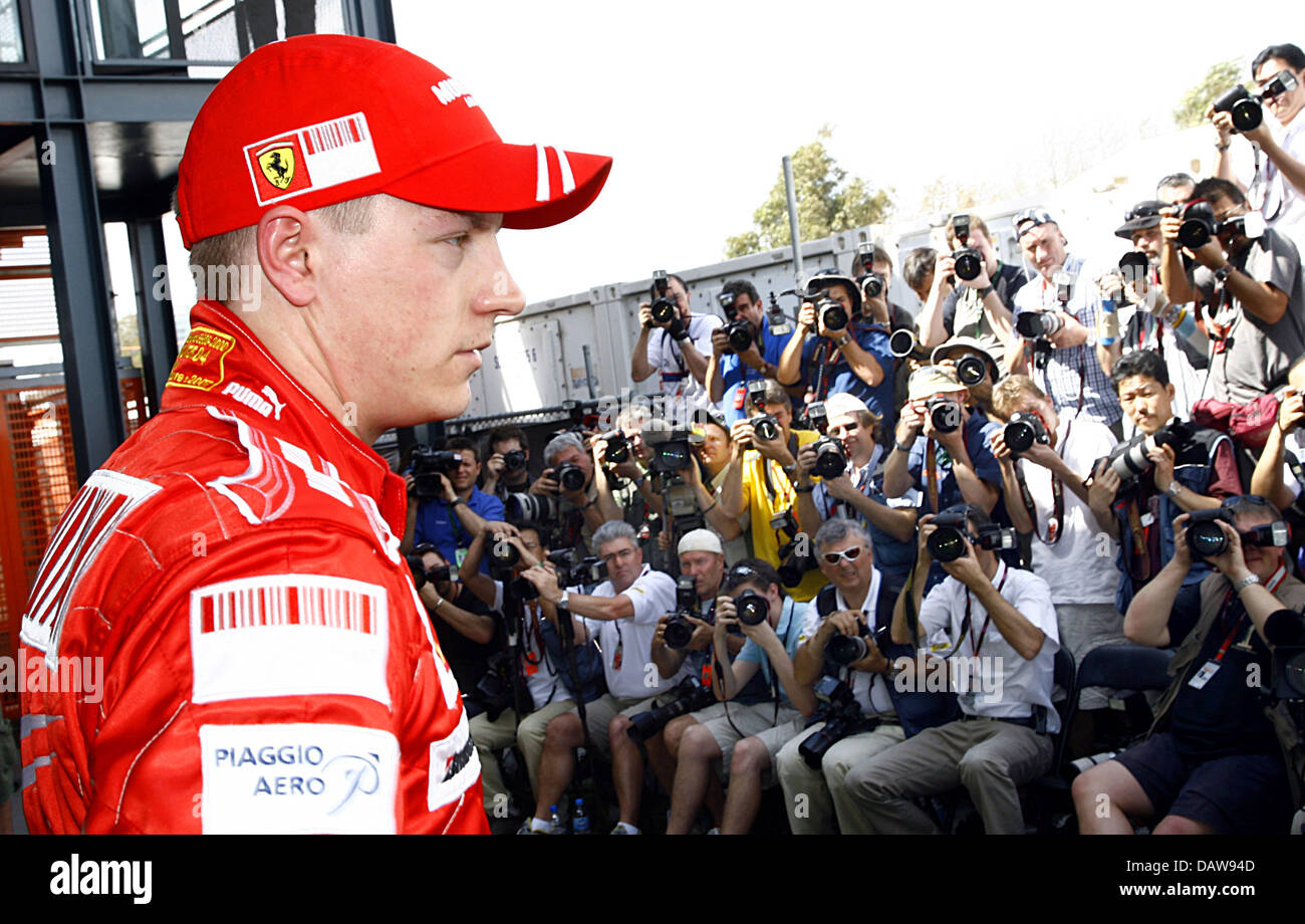 Finnish Formula One pilot Kimi Raikkonen (L) of Scuderia Ferrari poses ...