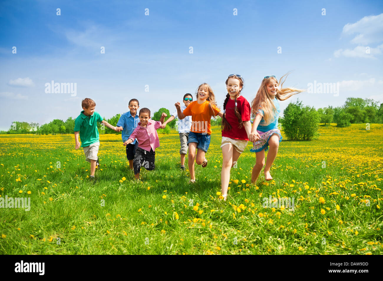 Large group of kids running in the dandelion spring field Stock Photo ...