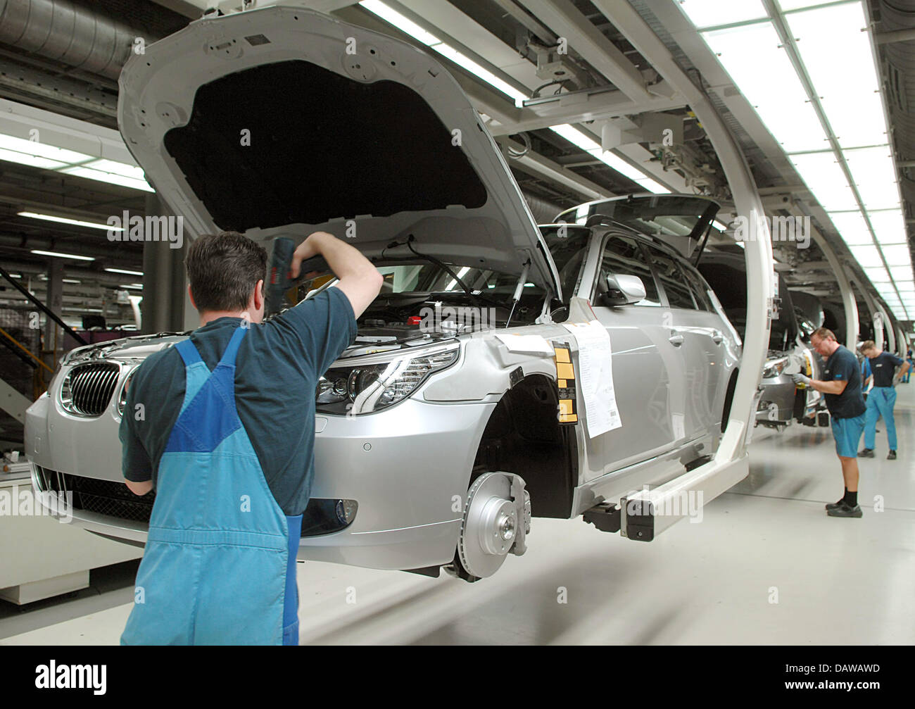 An employee of German carmaker BMW checks the engine of a BMW Series 5 ...