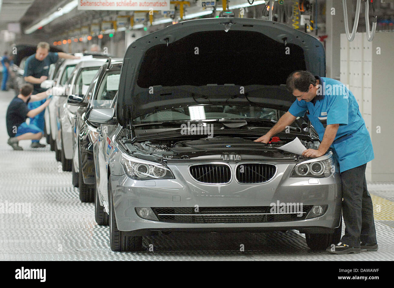 An employee of German carmaker BMW checks the engine compartment of a ...