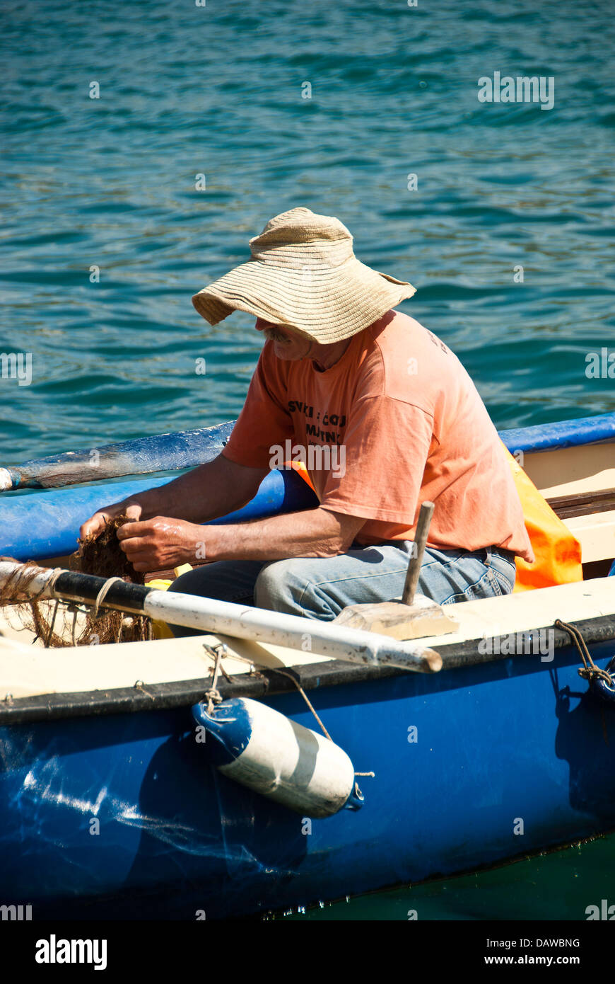 Fisherman repairing net Stock Photo - Alamy
