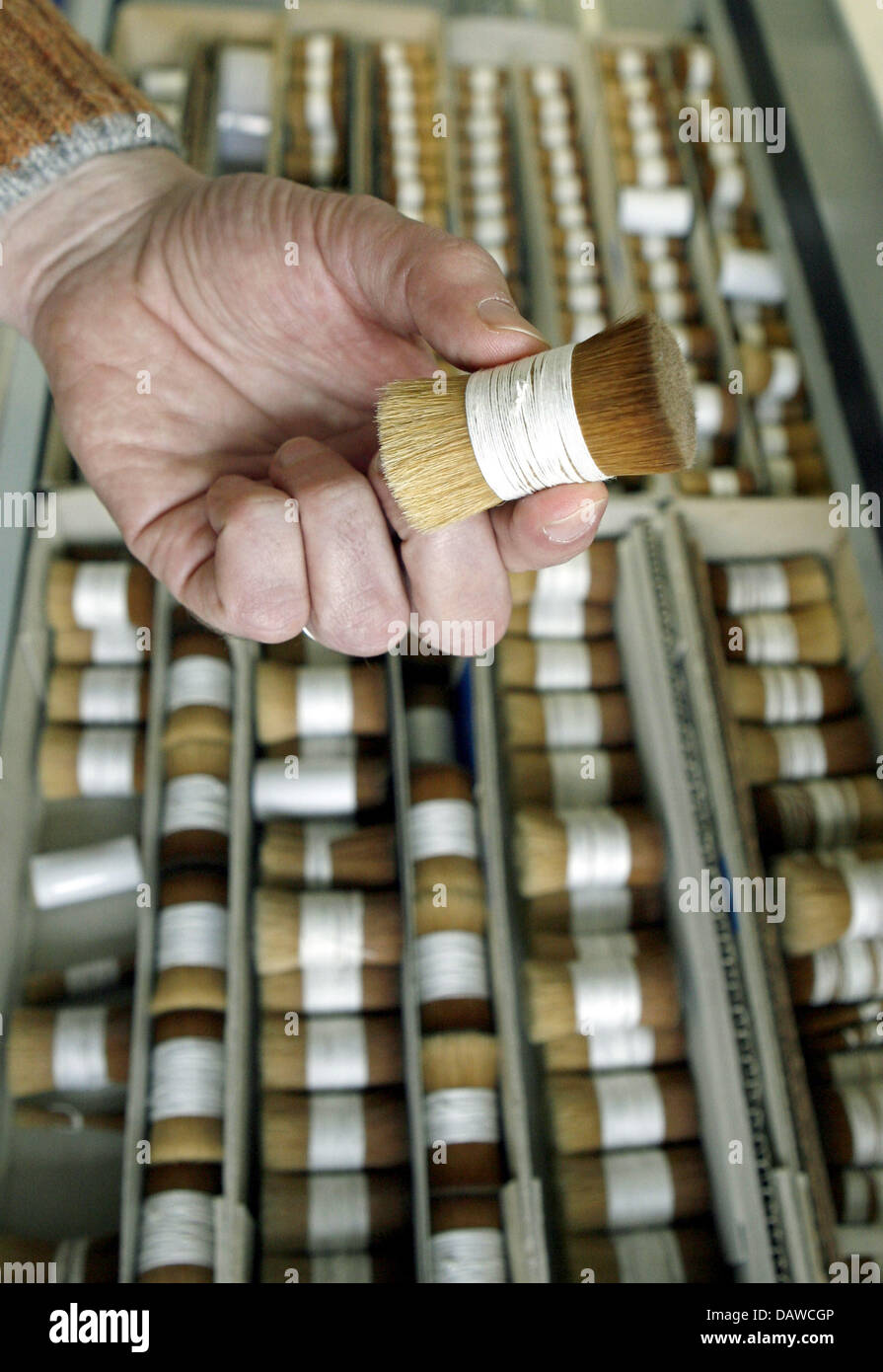 An employee holds a bundle of processed animal hair used for making ...