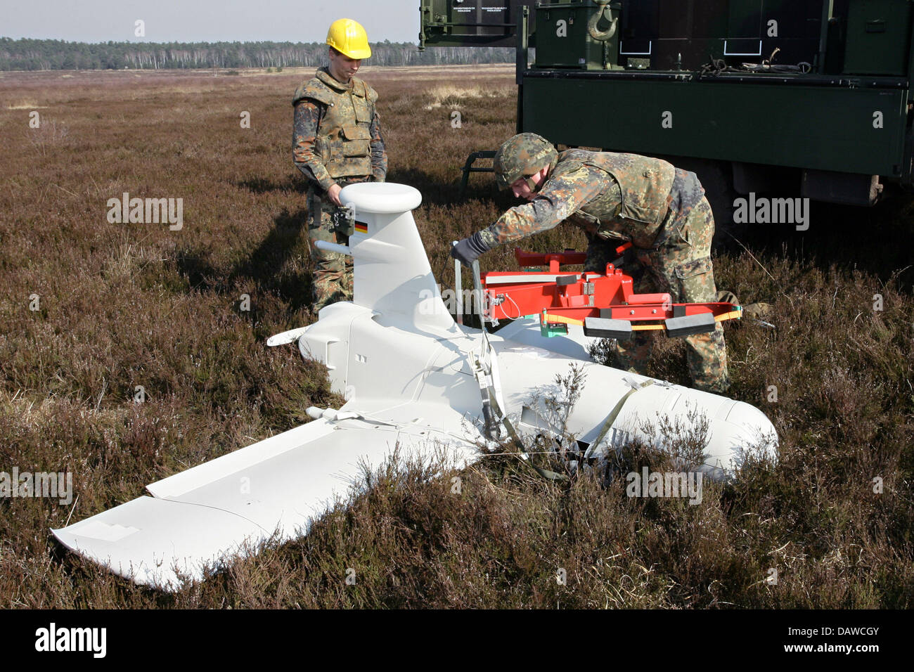 A new KZO reconnaissance drone is inspected by two soldiers at the ...