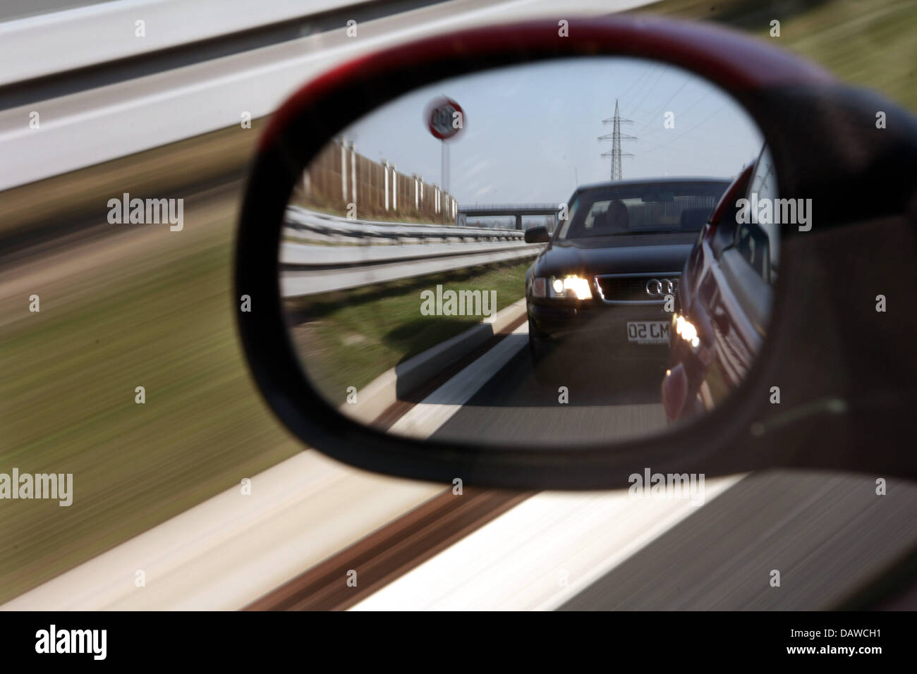 A pushy driver appears in the rear-view mirror of a car while driving ...