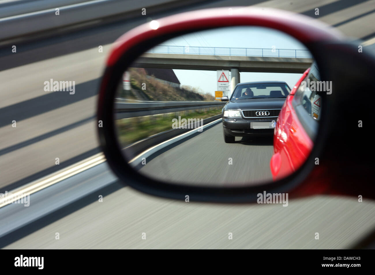 A pushy driver appears in the rear-view mirror of a car while driving ...