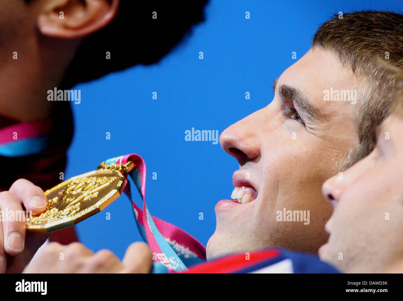 US swimmer Michael Phelps smiles with his gold medal for winning the ...