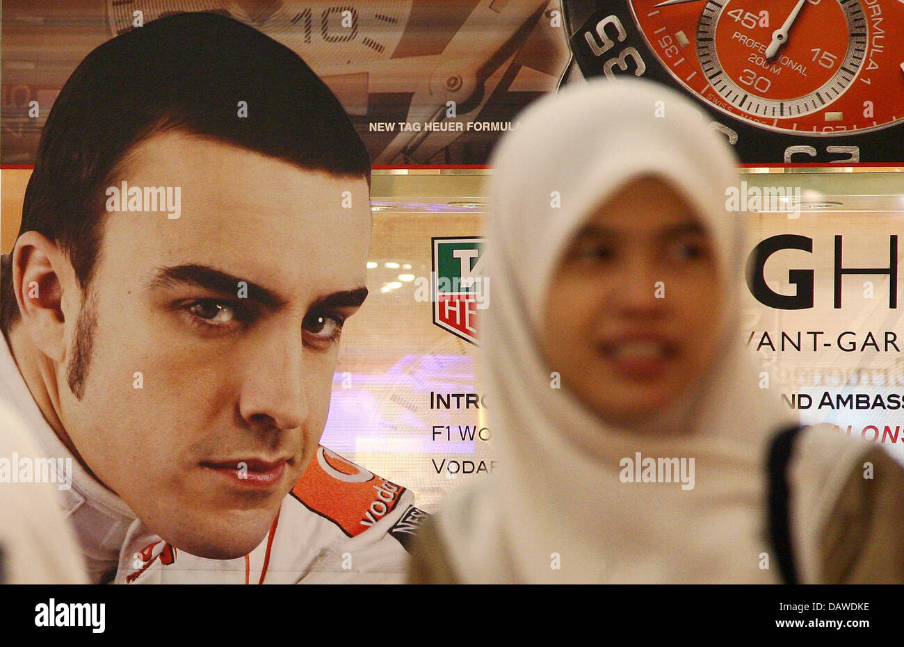 A woman pictured with an advert poster of Spanish Formula 1 reigning ...
