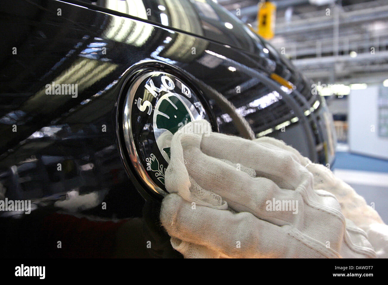 An employee polishes the Skoda logo of a Skoda Octavia on the assembly ...