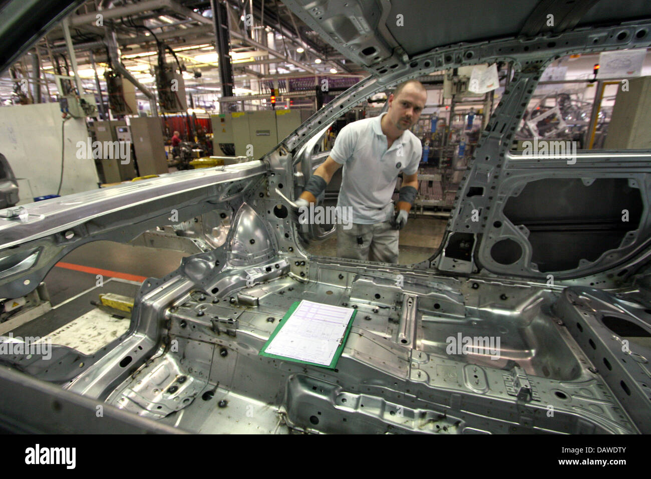 An employee examines a Skoda Octavia car body on the assembly line at ...