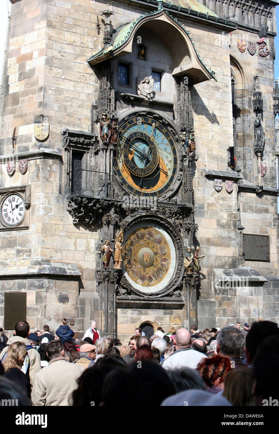 Tourists observe the famous Astronomical Clock mounted on the City Hall ...