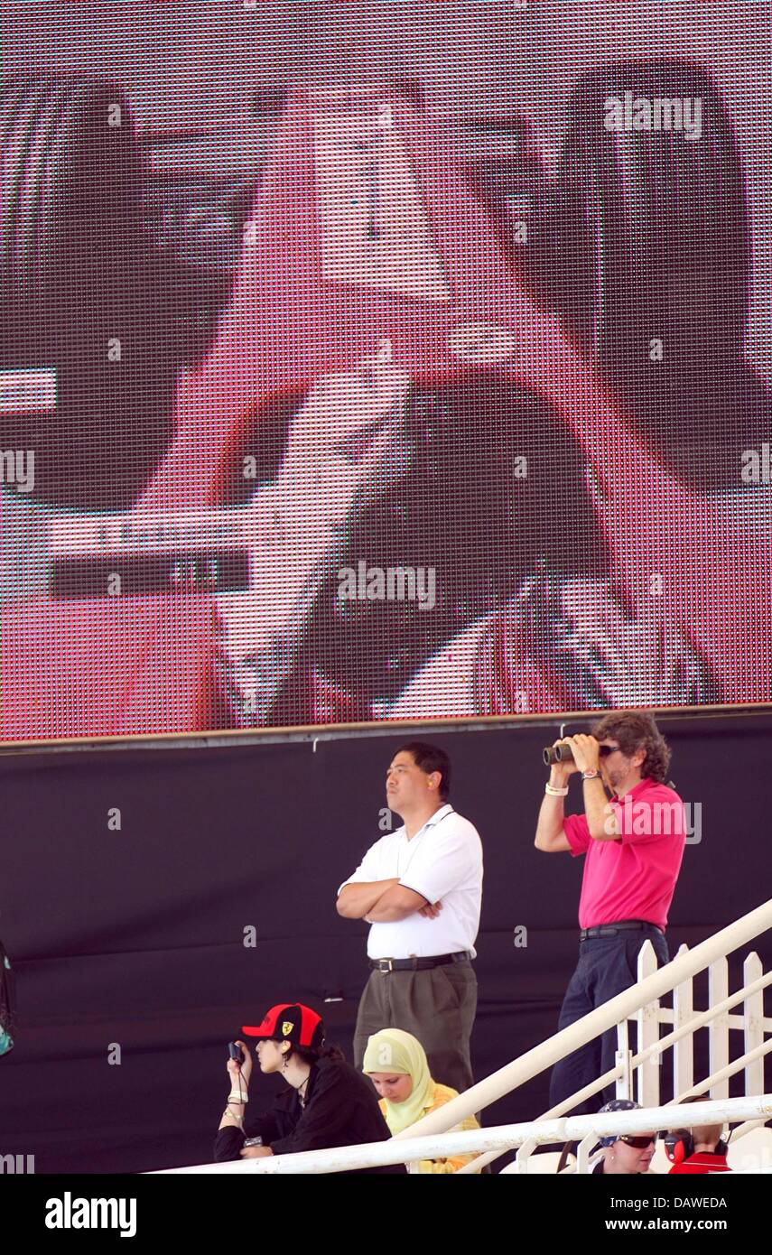Two Malaysian Formula 1 fans are pictured in front of a giant screen ...