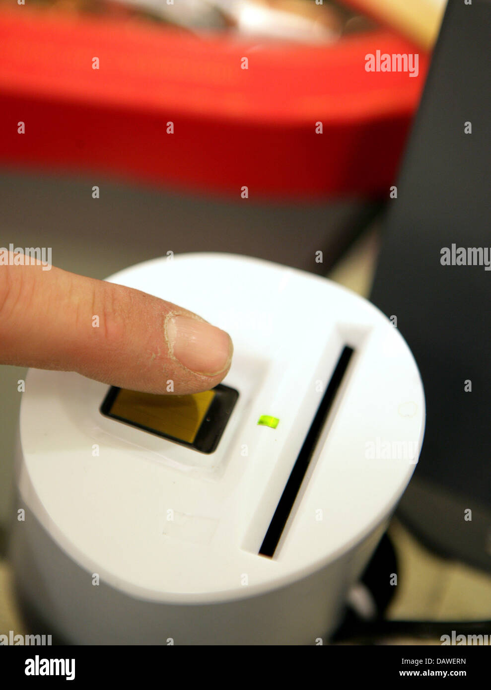 The picture shows a finger on the finger tip scanner at a cashier of a ...