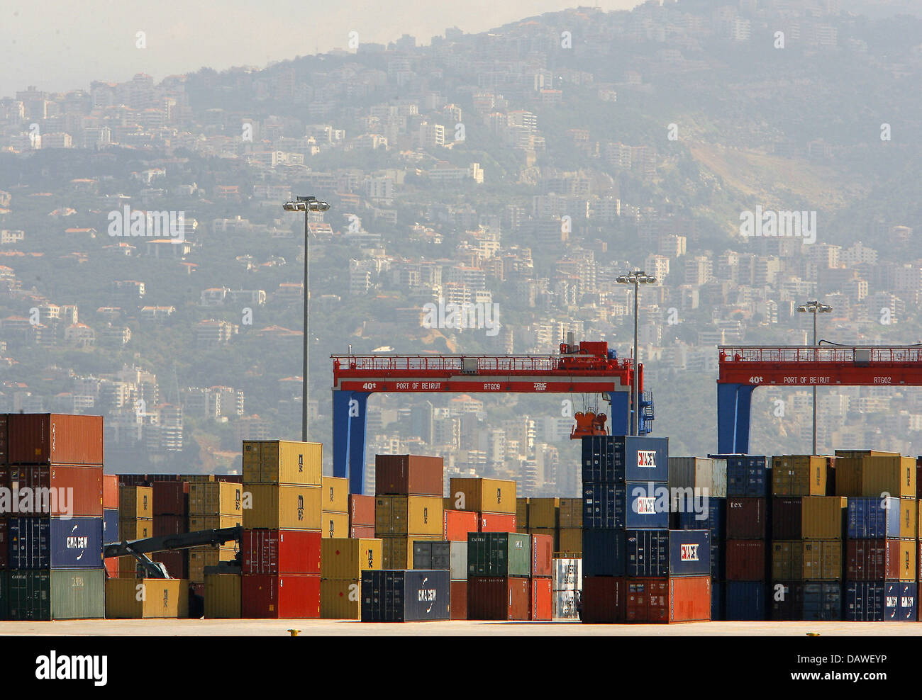 The photo shows piles of containers against the background of the hills ...