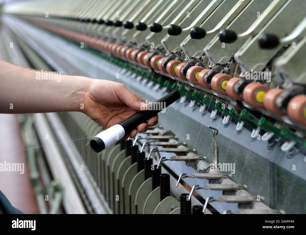 A worker operates the spinnery machine at the ADO Gardinenwerke mill in ...
