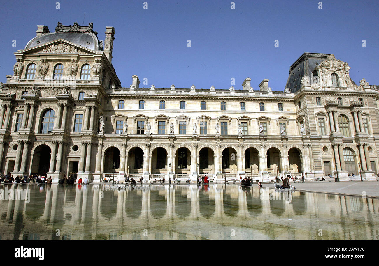 A part of the Louvre facade reflects in the courtyard pool in Paris ...