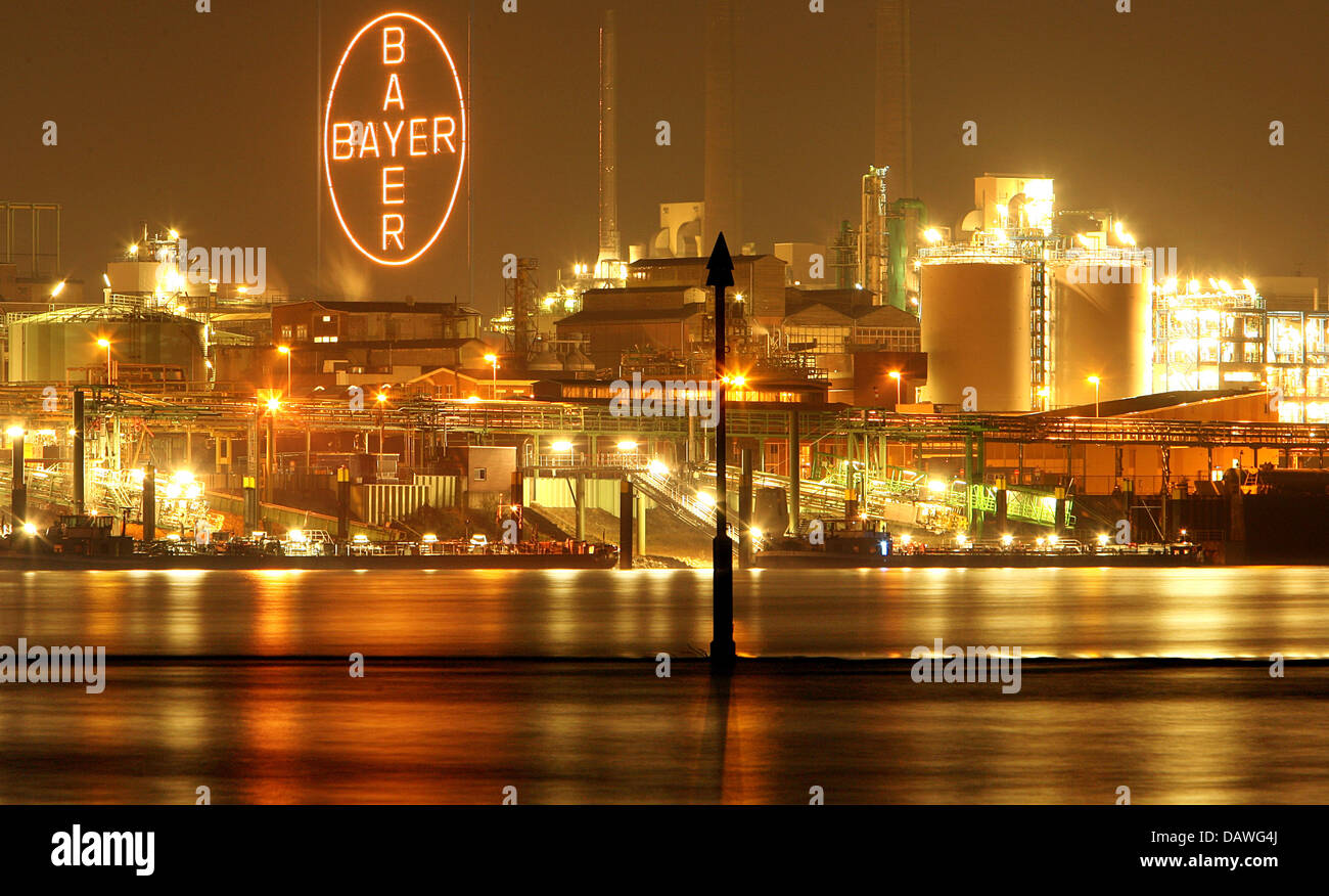 The lights of the Bayer main plant reflect in the river Rhine in ...