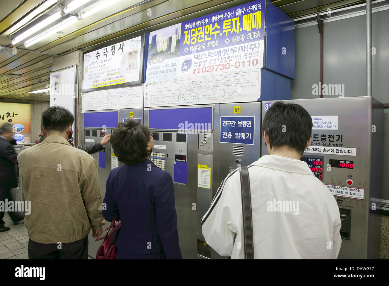 People queue in front of the ticket vending machines at the underground ...