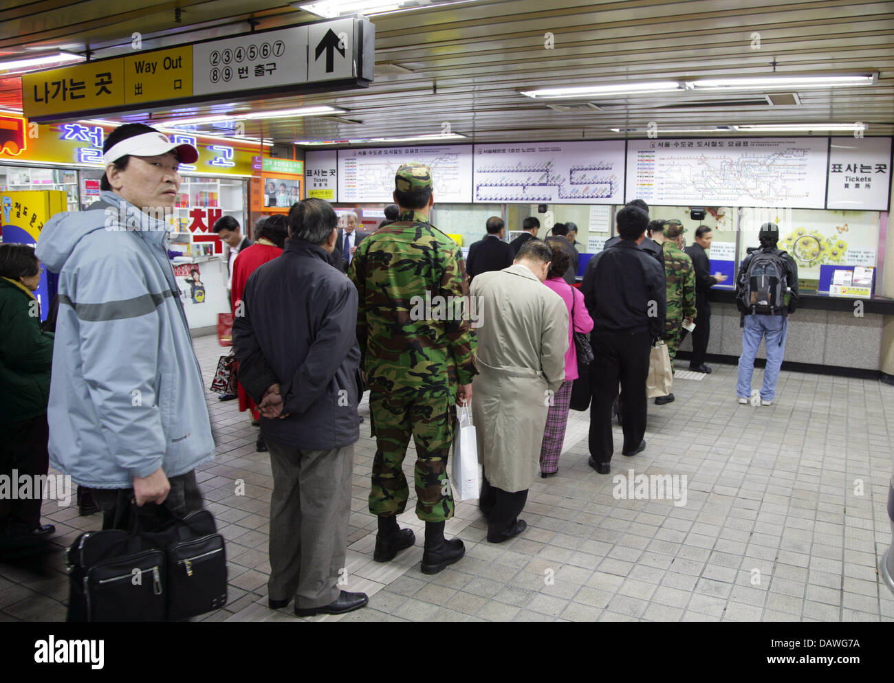 People queue in front of the ticket vending machines at the underground ...