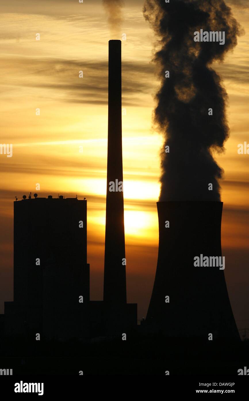 The sun sets behind the black coal-fired power plant of Mehrum, Germany ...