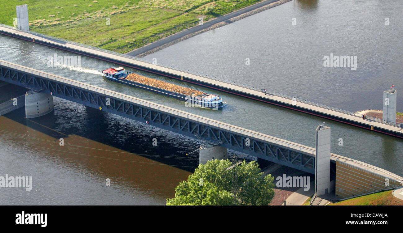 A barge transports cargo on the trough bridge crossing the River Elbe ...