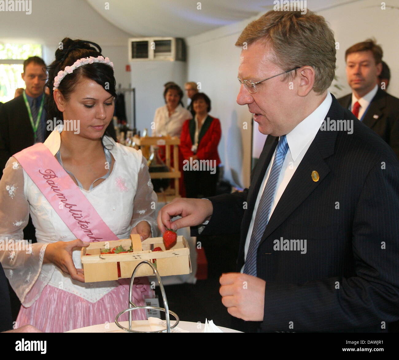 Russian Minister of Finance, Alexey Kudrin, takes a strawberry out of ...