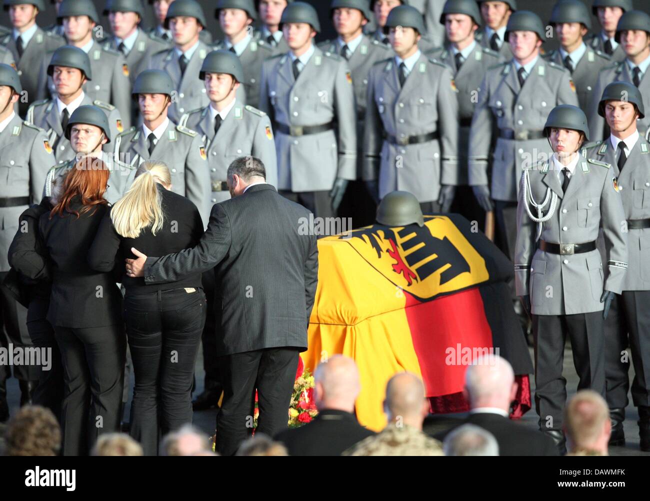 relatives and the guard of honour of the German Bundeswehr stand next ...