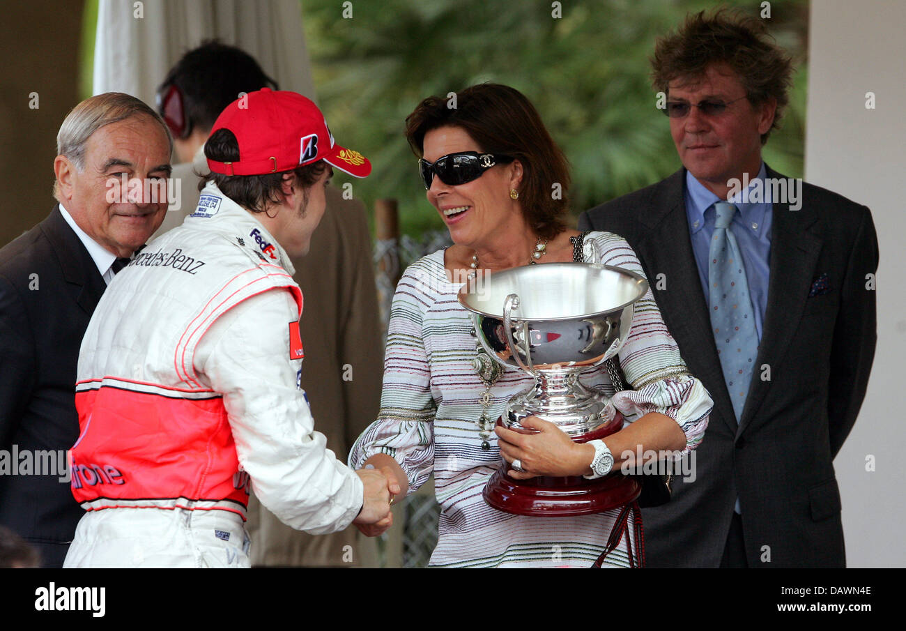 Spanish Formula One pilot Fernando Alonso (L) reveives the trophy from ...