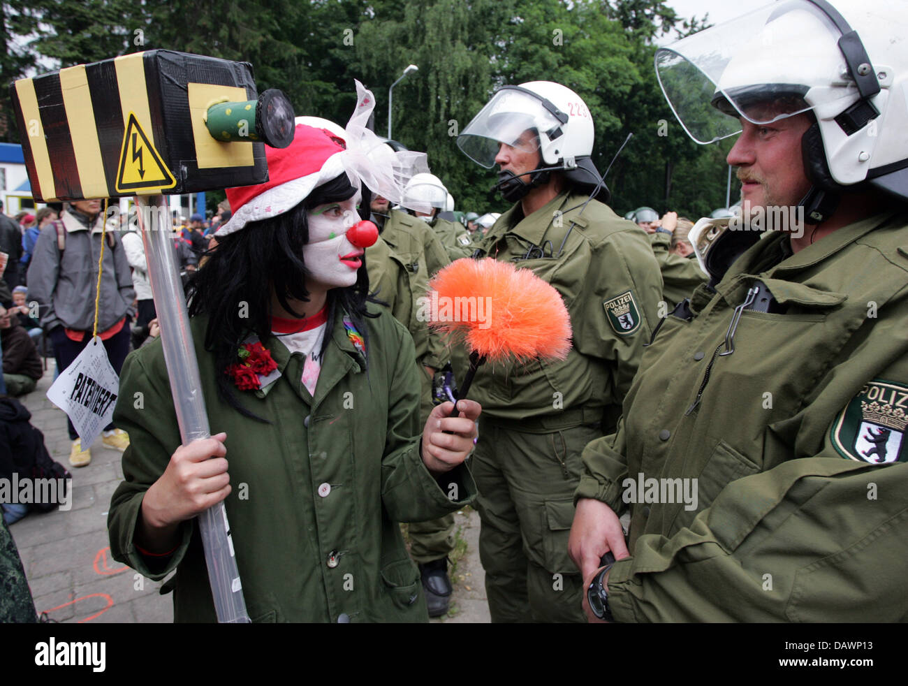 A G8 protester dressed up as a clown pretends to interview a police ...