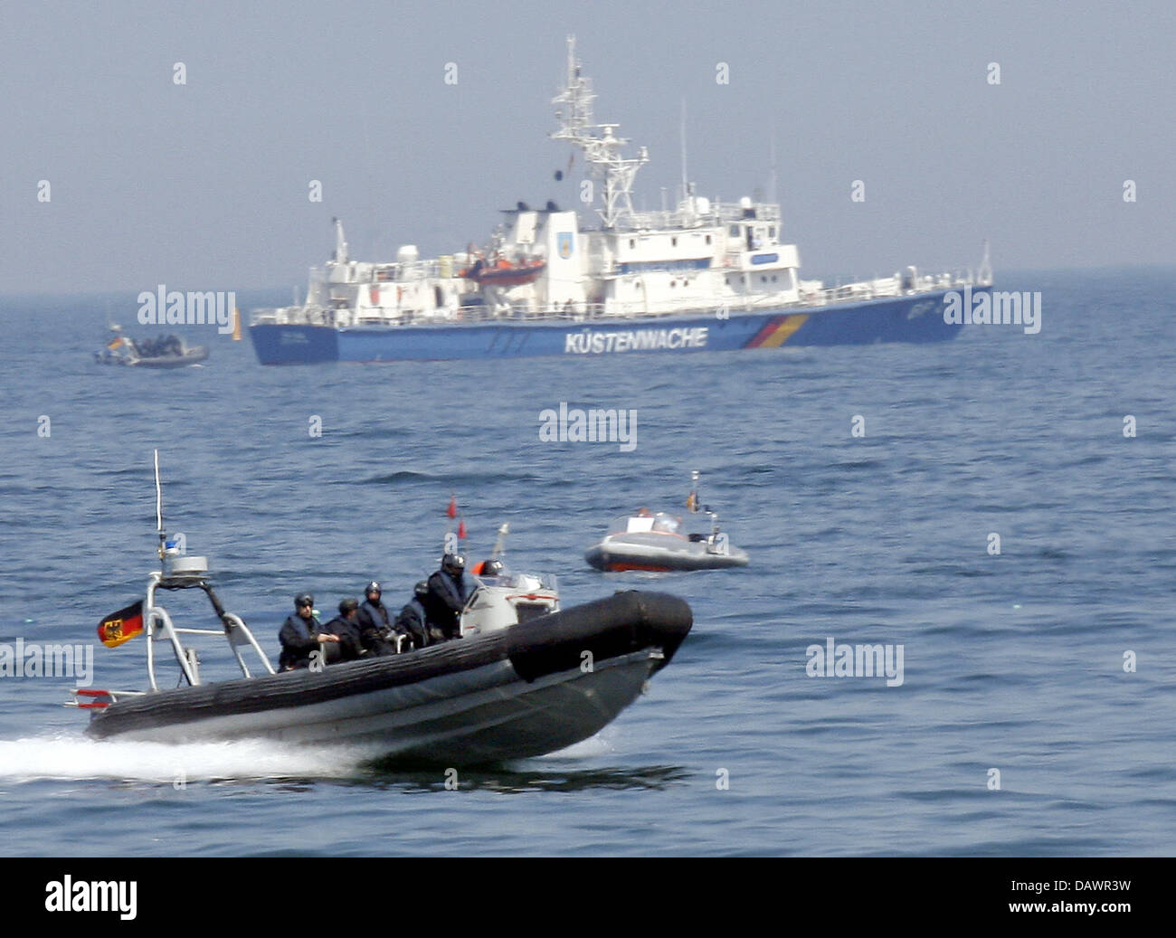 Boats of the German Coastal Guard and the police patrol the beach of ...