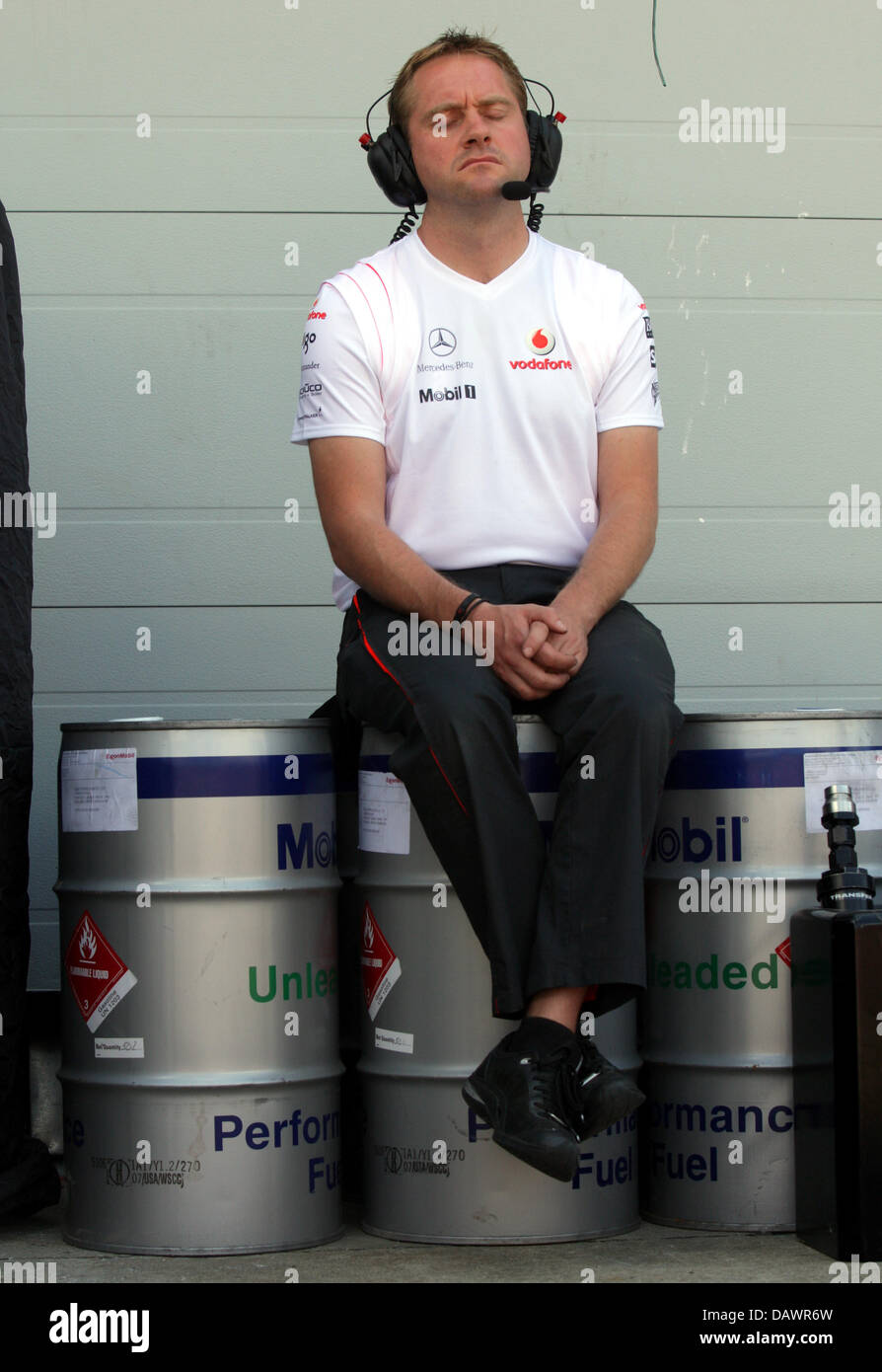 A McLaren Mercedes mechanic relaxes during the Practice 3 session at ...