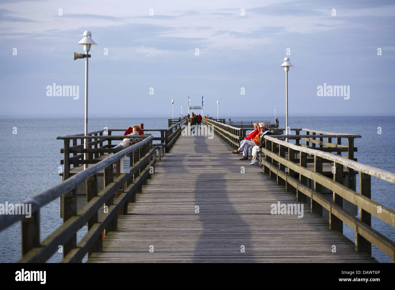 Tourists and residents sit on the wodden pier at the Baltic Sea in ...